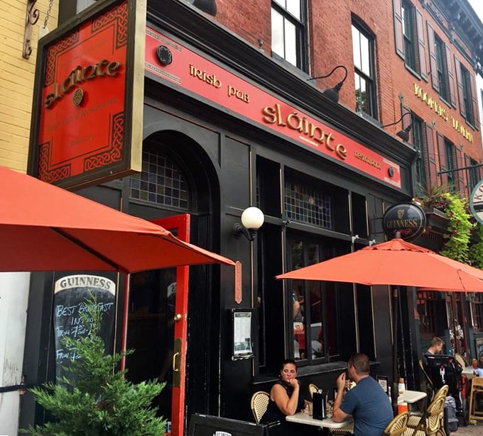 The crimson façade of Slainte stands proudly on Thames Street, Irish flag waving between American ones—a diplomatic sandwich of international goodwill.