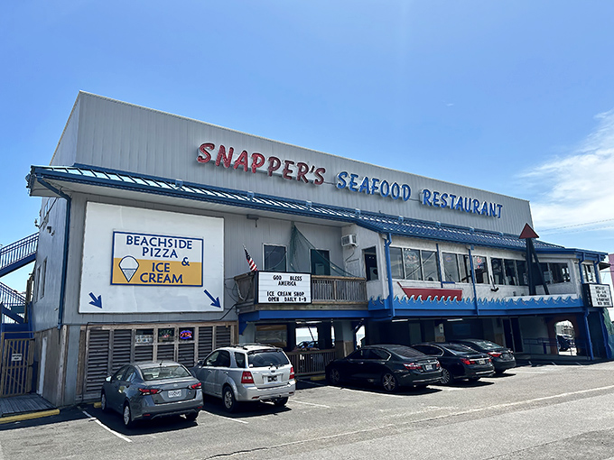 Snapper's iconic blue-trimmed exterior stands like a beacon for seafood lovers, with parking cleverly tucked underneath—Gulf Coast practicality at its finest.