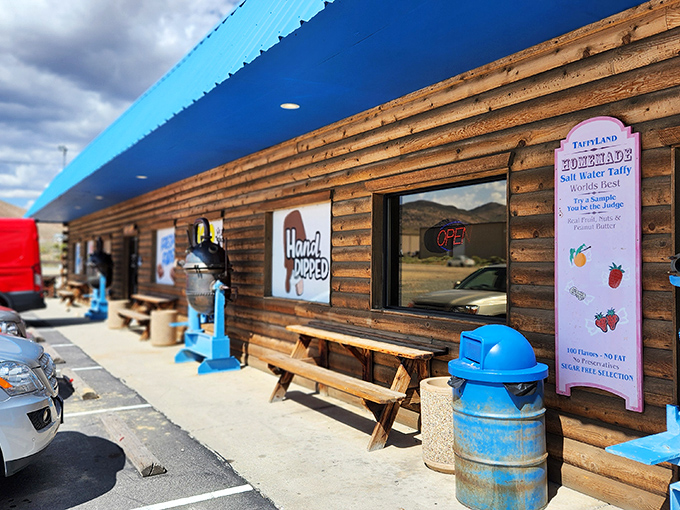 The rustic log cabin exterior of Chocolate Nugget beckons like a sweet mirage in the Nevada desert, complete with picnic tables for immediate sugar-rush recovery.