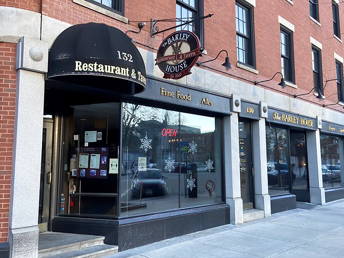 The classic red brick façade of The Barley House beckons like an old friend, with cheerful red umbrellas promising good times on the patio.