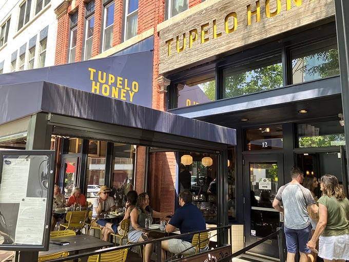 The golden-lettered storefront beckons like a Southern siren song, promising comfort food salvation on a busy Asheville street.
