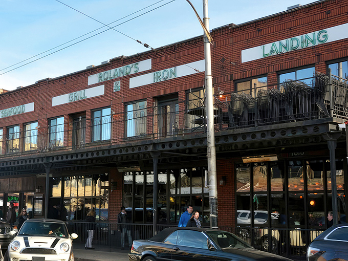 The iconic brick façade of Roland's stands proudly in Pittsburgh's Strip District, its neon-green signage promising oceanic delights in the heart of steel country.