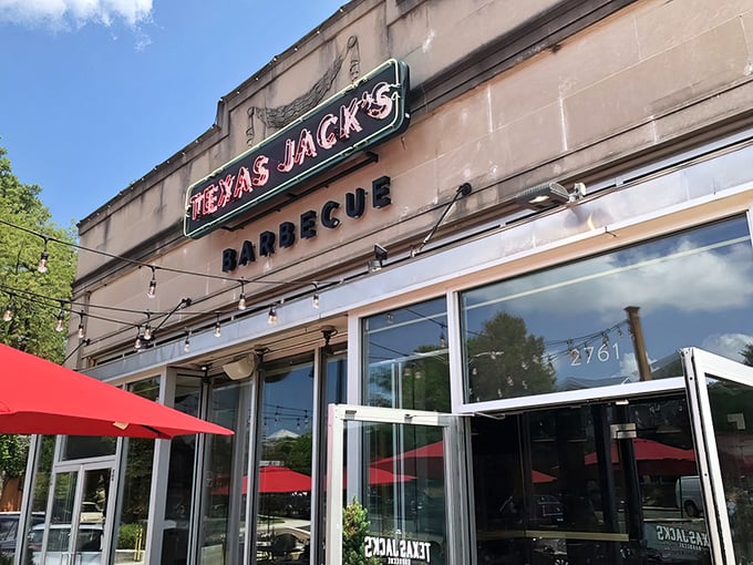 The inviting exterior of Texas Jack's Barbecue beckons with its vintage-style neon sign—like a beacon of smoky salvation on Arlington's Washington Boulevard.