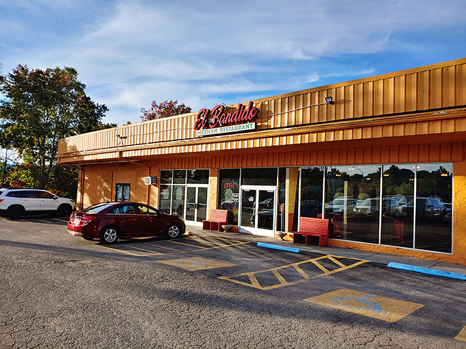 The golden glow of El Bandido's exterior promises culinary treasures within. Those red benches aren't just seating—they're the waiting room for flavor paradise.