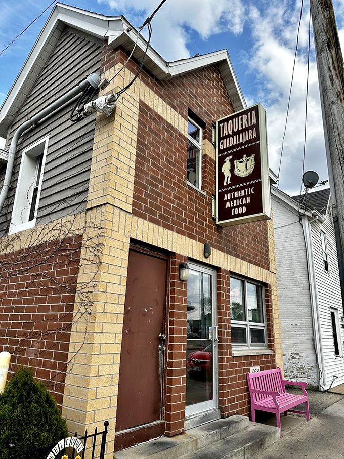 The unassuming brick exterior with that eye-catching pink bench is like a secret handshake – those who know, know this is where Madison's burrito magic happens.