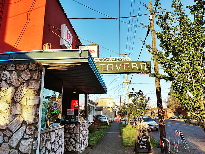 The iconic stone facade and vintage neon sign of Mock Crest Tavern stands as a beacon for breakfast seekers in North Portland.