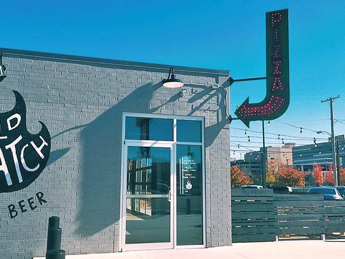 That neon arrow isn't just pointing to a restaurant—it's directing you to your new pizza obsession. Industrial chic meets culinary magic at Old Scratch's unassuming exterior.