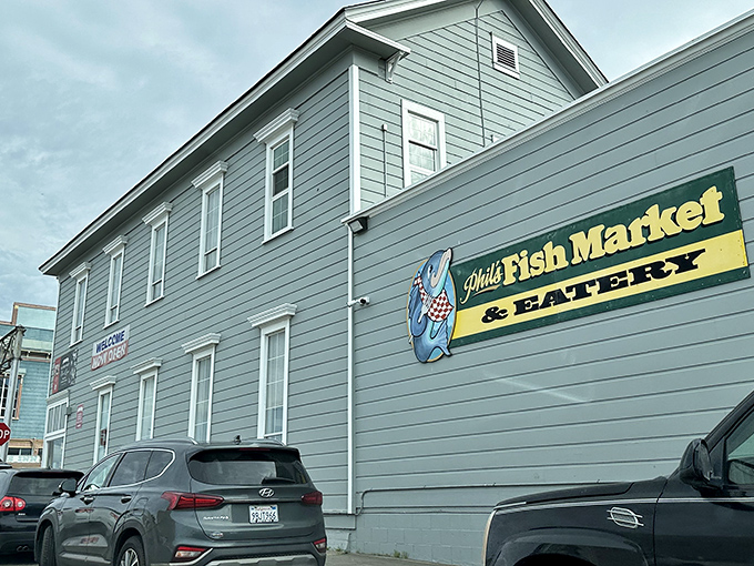 The unassuming exterior of Phil's Fish Market & Eatery stands like a seafood speakeasy – complete with nautical guardians who've seen a thousand hungry pilgrims arrive skeptical and leave converted.