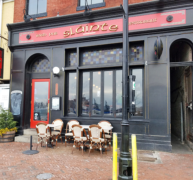 The crimson façade of Slainte stands proudly on Thames Street, Irish flag waving between American ones—a diplomatic sandwich of international goodwill.