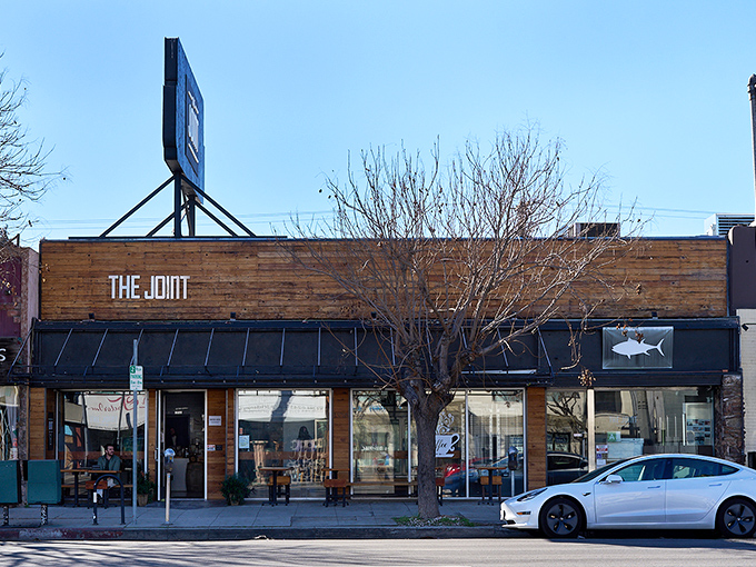 The wooden façade of The Joint feels like a secret handshake – understated, welcoming, and promising something special behind those doors.