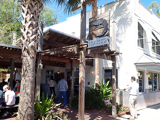 That weathered wooden shrimp sign swinging in the Florida breeze isn't just decoration—it's a beacon calling seafood lovers home to Timoti's charming Fernandina Beach location. 