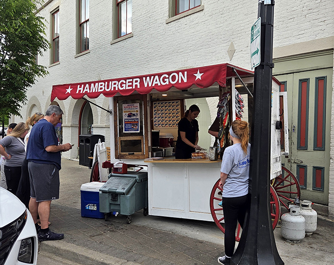 The iconic Hamburger Wagon stands proudly on Miamisburg's Main Street, its red awning and wagon wheels a beacon for burger enthusiasts since 1913. 