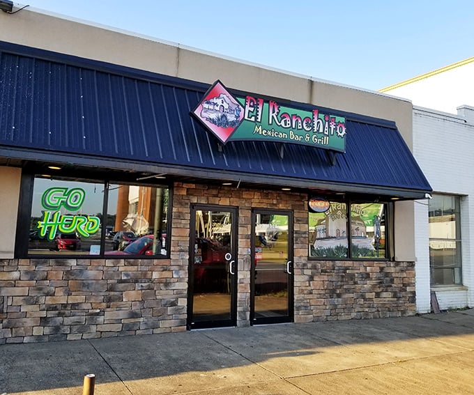 The vibrant storefront of El Ranchito glows like a beacon of culinary promise, its colorful signage and stone facade practically shouting "authentic Mexican food happens here!"
