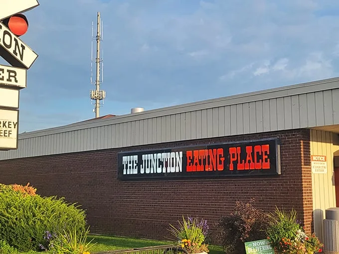 The railroad crossing sign perched atop this unassuming DeKalb diner isn't just decoration—it's a promise of the journey your taste buds are about to take.