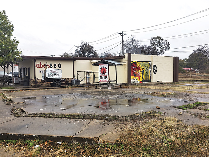The humble yellow exterior of Abe's Bar-B-Q stands like a beacon at Clarksdale's famous crossroads, wooden picnic tables inviting weary travelers to sit a spell.