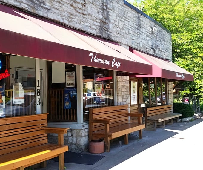 The stone facade and bright red awnings of Thurman Cafe stand like a culinary fortress in Columbus's German Village, promising burger adventures within.