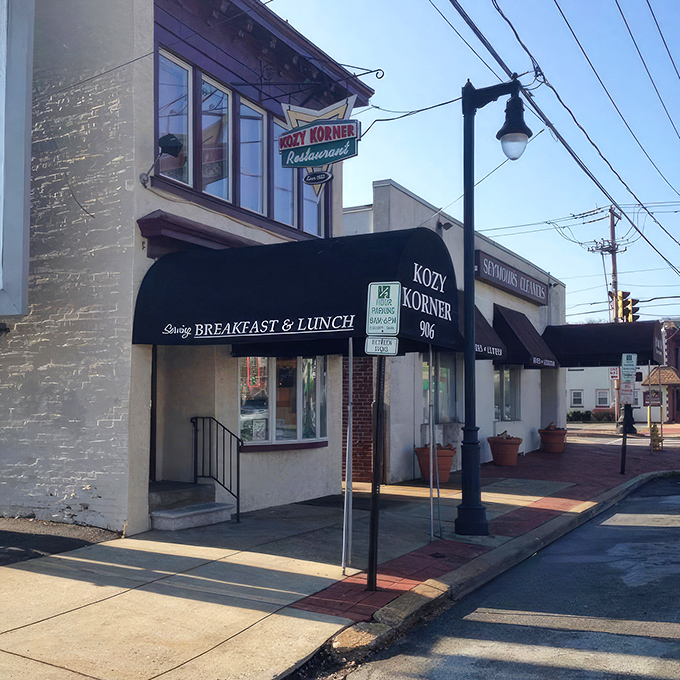 The vintage sign beckons like an old friend, promising comfort food salvation beneath that classic black awning. Breakfast paradise awaits.