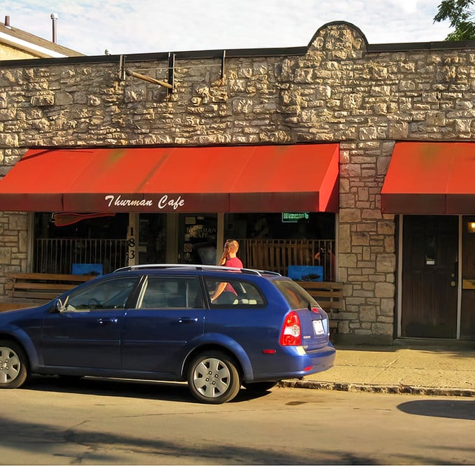 The stone facade and bright red awnings of Thurman Cafe stand like a culinary fortress in Columbus's German Village, promising burger adventures within.