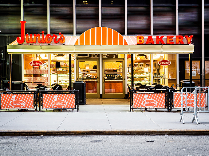 The iconic orange and white façade of Junior's glows like a beacon for cheesecake pilgrims, promising sweet salvation in a busy city.