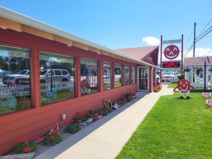 The Cherry Hut's cheerful red exterior isn't just a building—it's a promise of the ruby delights waiting inside. Complete with Cherry Jerry mascot standing guard!