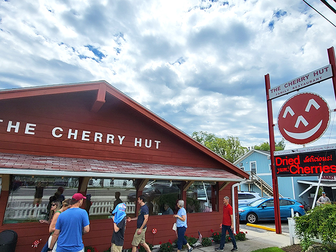 The Cherry Hut's cheerful red exterior isn't just a building—it's a promise of the ruby delights waiting inside. Complete with Cherry Jerry mascot standing guard!