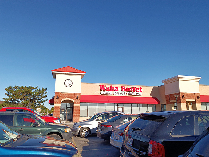 The bright red signage of Waha Buffet stands out like a culinary lighthouse, beckoning hungry travelers with promises of sushi, seafood, and pho paradise.