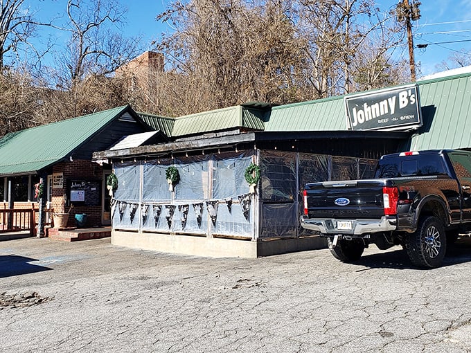 The unassuming green-roofed treasure of Dahlonega beckons with its weathered charm and plastic-enclosed patio—culinary gold hiding in plain sight.