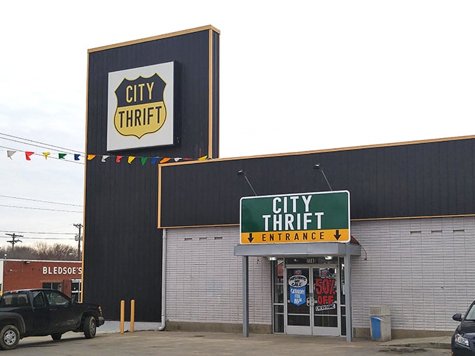The iconic black and yellow City Thrift sign stands like a beacon of bargain hope, promising treasures waiting to be discovered inside.