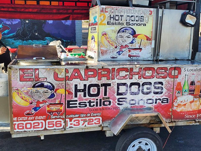 The humble chariot of flavor! El Caprichoso's colorful food cart promises bacon-wrapped bliss that's worth every minute in line.