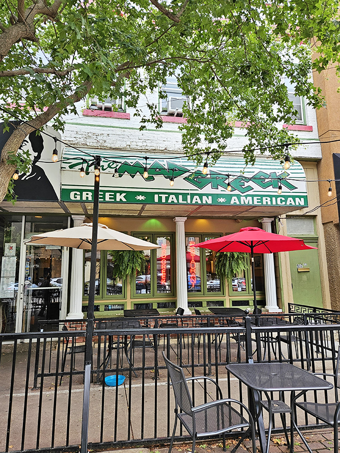 The Mad Greek's inviting storefront beckons with classic white columns and cheerful patio umbrellas—Massachusetts Street's little slice of Athens awaits your discovery.