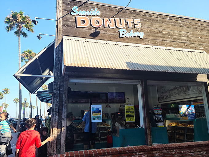 Palm trees stand sentry outside Seaside Donuts' wooden facade, nature's exclamation points announcing: "Something delicious happens here!"