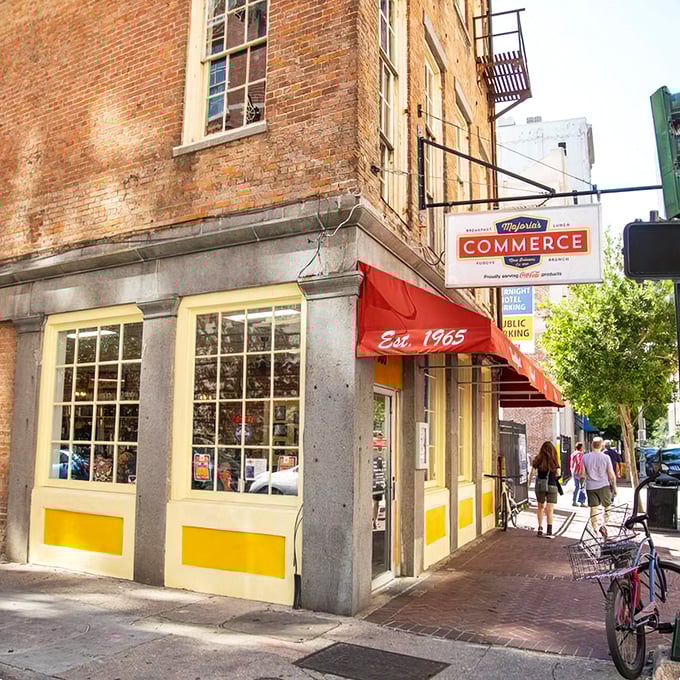 The iconic red awning of Majoria's Commerce Restaurant stands out against historic brick, a beacon for breakfast pilgrims in New Orleans' CBD.