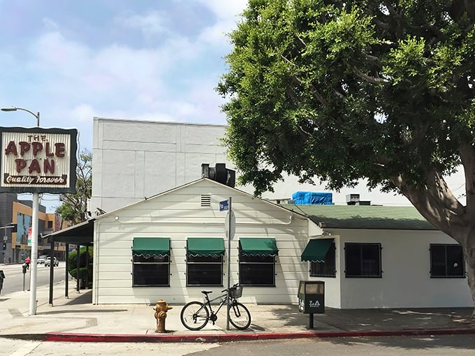 The unassuming white exterior of The Apple Pan stands like a time capsule on West Pico Boulevard, its vintage sign promising "Quality Forever" – a bold claim it's managed to fulfill for decades.