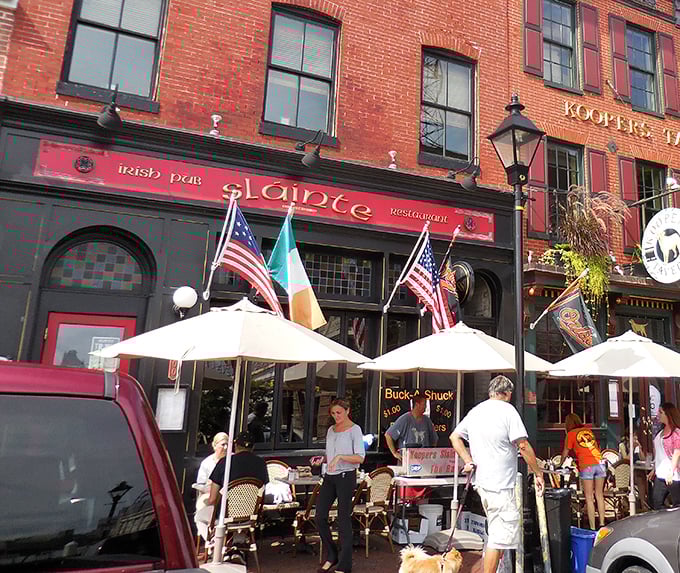 The crimson façade of Slainte stands proudly on Thames Street, Irish flag waving between American ones—a diplomatic sandwich of international goodwill.