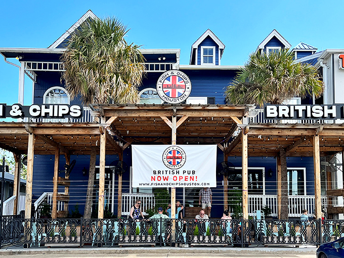 The blue facade of Fish and Chips Houston stands proudly in Kemah, where palm trees and Union Jacks create the most delightful cultural collision since tea met Texas.