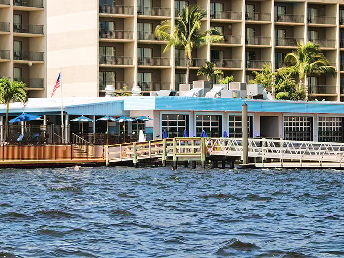 The blue-roofed waterfront gem beckons like a siren song, promising seafood treasures where the Caloosahatchee River meets your appetite.