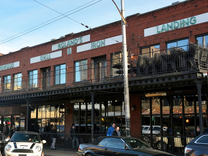 The iconic brick façade of Roland's stands proudly in Pittsburgh's Strip District, its neon-green signage promising oceanic delights in the heart of steel country.