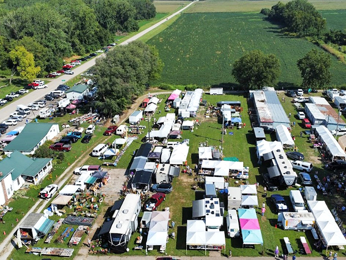 An aerial view reveals Sparks Flea Market's true scale—a sprawling treasure hunter's paradise nestled among Kansas farmland, where parking lots fill with hopeful bargain seekers.