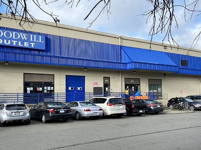 The blue-trimmed exterior of Seattle Outlet Goodwill stands like a portal to bargain dimension—where treasures await those brave enough to enter. 