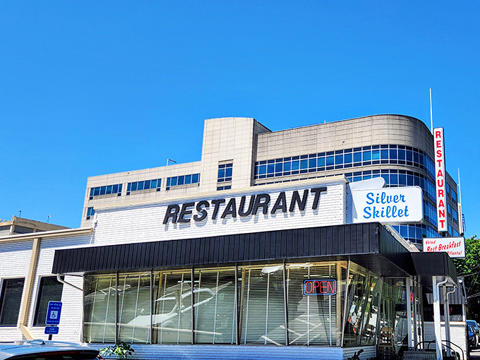 The Silver Skillet's mid-century exterior glows like a time capsule at dusk, beckoning hungry travelers with promises of Southern comfort and nostalgia.