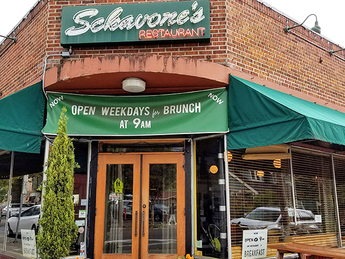 The corner brick building glows like a lighthouse for hungry souls, its green awnings and twinkling lights promising comfort on even the dreariest Portland evening.