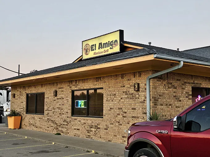 The unassuming brick exterior of El Amigo Feliz stands like a culinary oasis in Hazen, bright orange planters hinting at the vibrant flavors waiting inside.