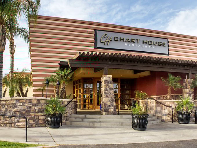 The Chart House exterior welcomes you with its distinctive horizontal stripes and stone accents—like a mid-century modern postcard that promises good times and better meals inside.