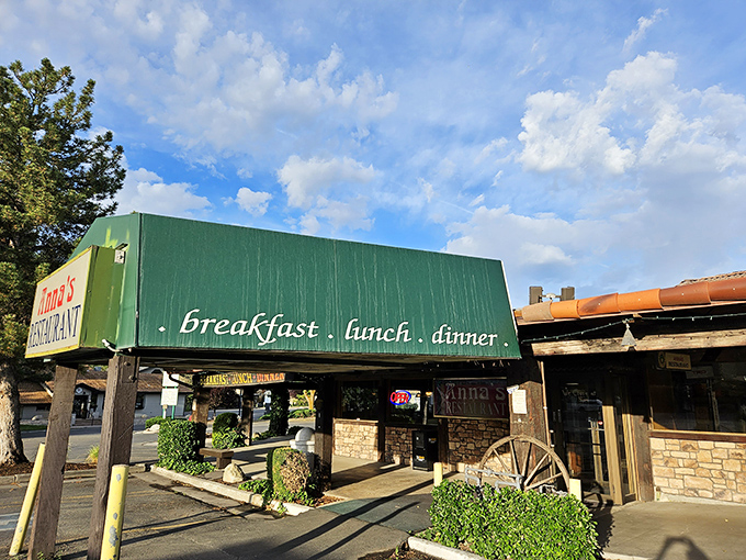 Anna's iconic green-roofed entrance beckons hungry travelers like a breakfast lighthouse on the shores of suburban Murray. The stone façade promises comfort within.