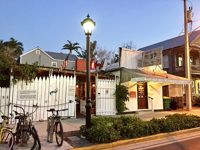 The white picket fence and vintage lamp post aren't just charming decor—they're time machines to Old Florida, where bicycles outnumber BMWs.