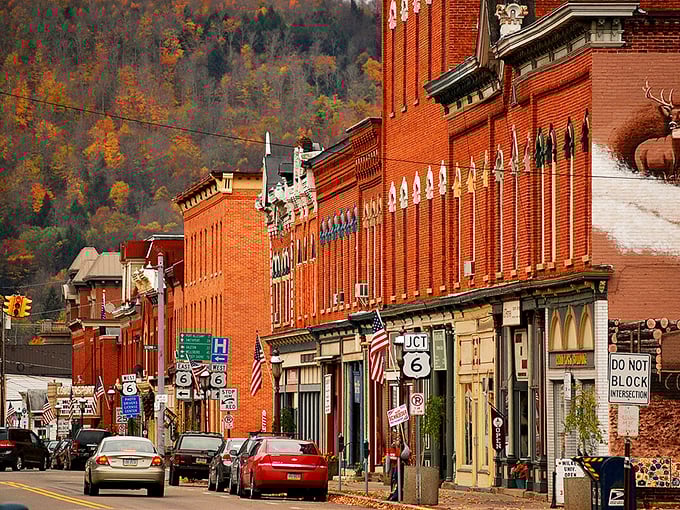 Main Street Coudersport in autumn glory – where brick buildings stand like sentinels against a backdrop of hills ablaze with fall foliage. Small-town America at its most photogenic.