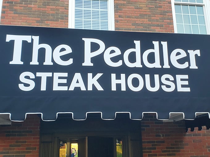 The brick façade of The Peddler stands like a carnivore's lighthouse, beckoning hungry travelers with its classic steakhouse promise. Some buildings just look delicious.