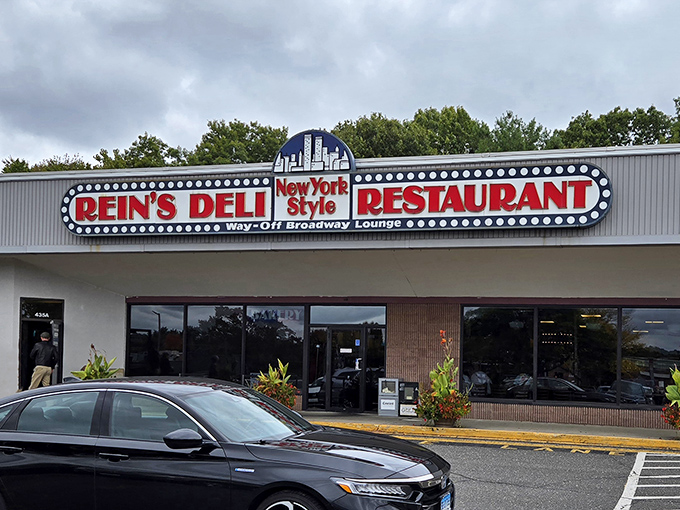 The iconic Rein's Deli sign glows like a beacon for hungry travelers on I-84, promising authentic New York deli magic in the heart of Connecticut.