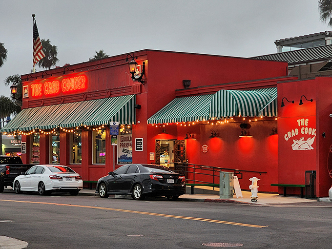The iconic crimson exterior of The Crab Cooker, with its cheeky "DON'T LOOK UP HERE" fish sign, stands as Newport Beach's delicious rebellion against pretension.