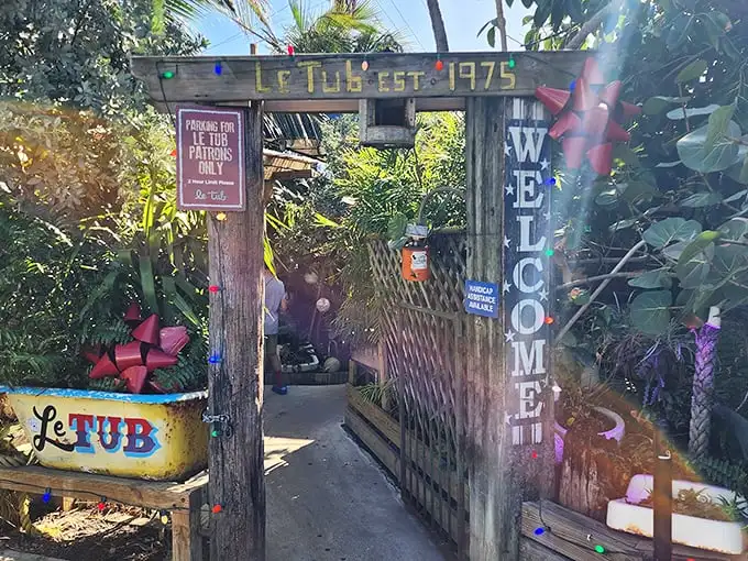 The unassuming wooden fence and yellow sign of Le Tub are Florida's version of a speakeasy entrance—secrets and seafood await behind these weathered boards.